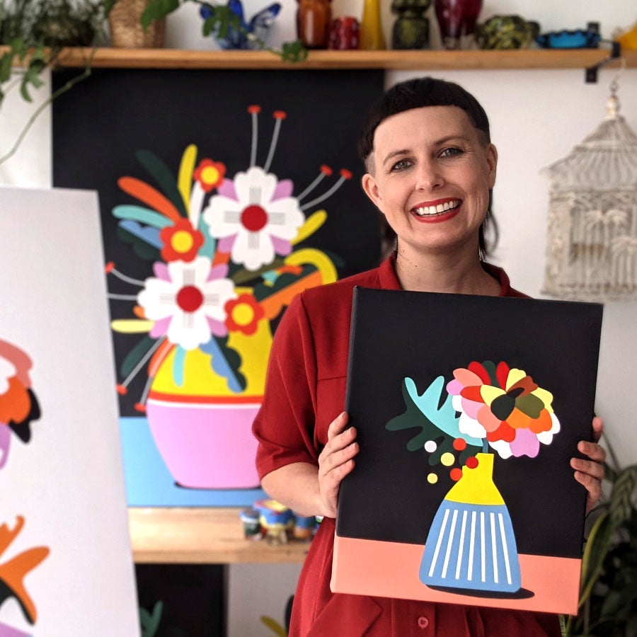 Australian artist Andria beighton holds a small floral artwork in her ...